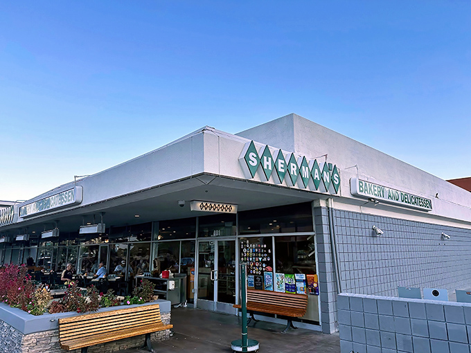 The desert sun gleams off Sherman's iconic white exterior and green diamond logo, a Palm Springs landmark promising deli delights within.