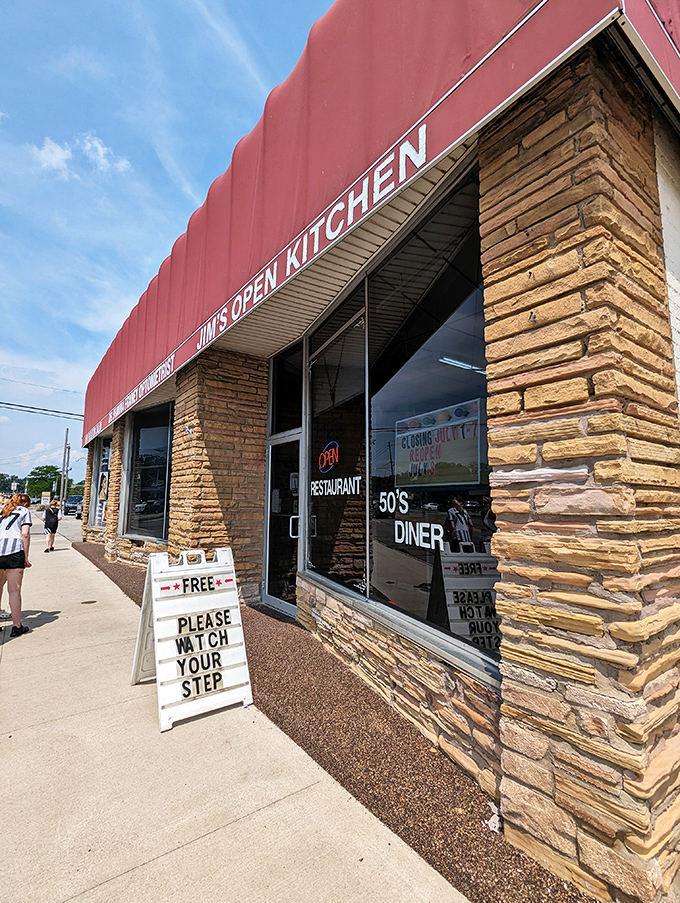 The stone facade and bold red awning of Jim's Open Kitchen stands as a beacon of hope for hungry travelers. Watch your step into breakfast paradise!