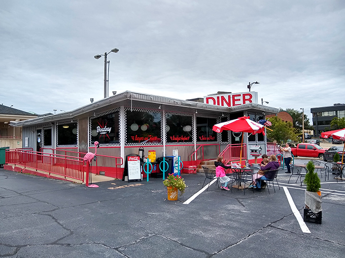 The classic red and white exterior of Broadway Diner stands like a time capsule of Americana, complete with that iconic neon sign beckoning hungry travelers.
