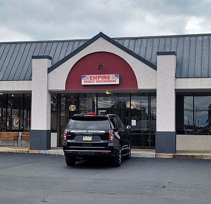 The red-arched entrance of Empire Family Diner stands like a beacon of breakfast hope in Norristown. Morning salvation awaits inside.