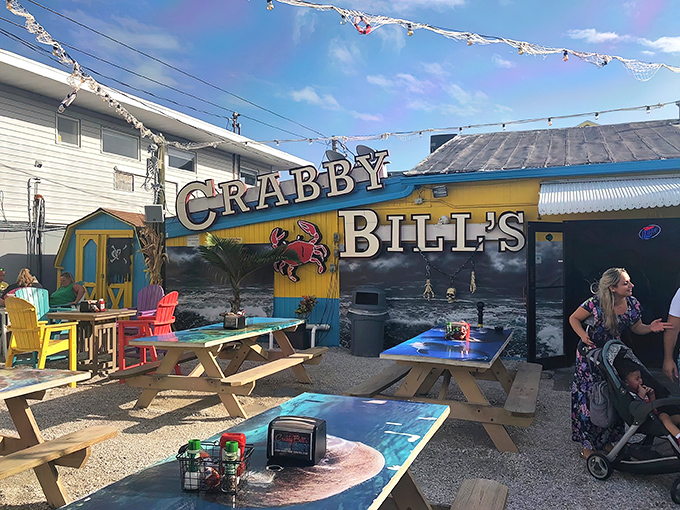 The iconic yellow and blue exterior of Crabby Bill's, where that boat on the roof isn't just decoration&mdash;it's a promise of seafood so fresh it practically swam to your table.