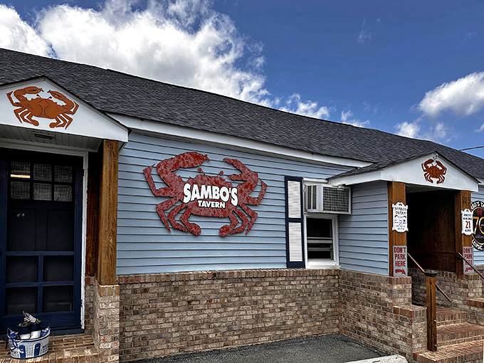 The blue exterior of Sambo's Tavern stands as a beacon for crab lovers, with those giant red crabs practically screaming, "Get in here, hungry traveler!"