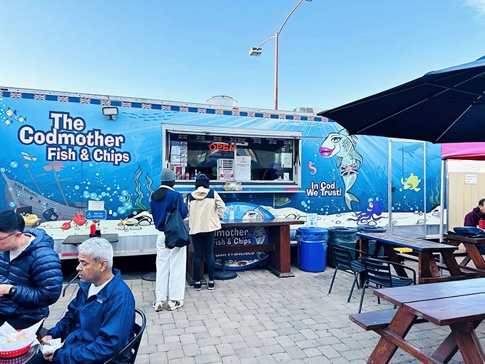 The bright blue food truck stands out like a maritime beacon at Fisherman's Wharf, promising British comfort food with its cheeky "In Cod We Trust" slogan.