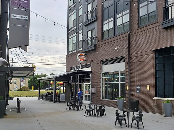 Bad Daddy's modern brick exterior beckons burger lovers with its inviting patio seating and string lights&mdash;urban comfort food paradise in Chamblee's evolving landscape.