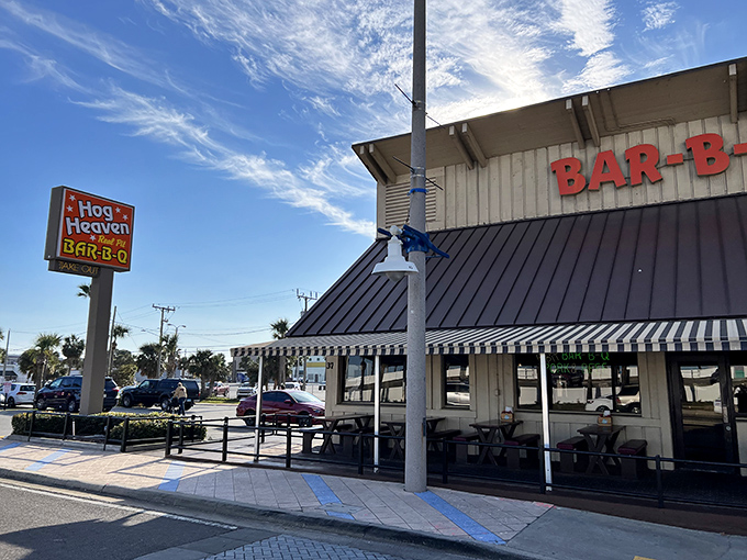 The iconic Hog Heaven sign beckons like a barbecue lighthouse against the Florida sky, promising smoky delights just steps from Daytona's famous beach.