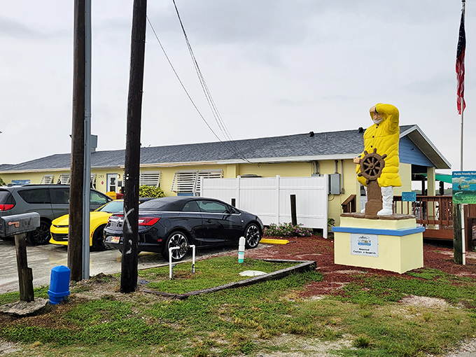 The cheerful yellow fisherman statue stands guard like a maritime sentinel, promising seafood treasures within this unassuming waterfront gem.
