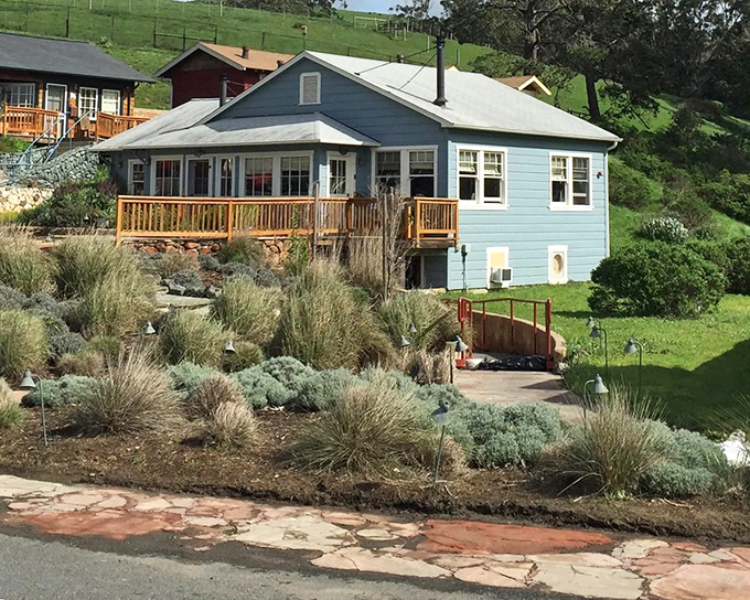 Sunset paints these waterfront homes in golden light, where residents enjoy front-row seats to nature's nightly show. Tomales Bay living at its most picturesque.