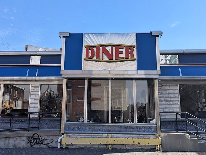 The classic blue and silver exterior of Broad Street Diner gleams like a beacon of breakfast hope on Philadelphia's urban landscape.