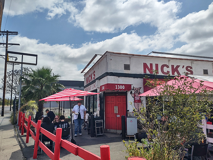 The iconic red-trimmed exterior of Nick's Caf&eacute; stands like a beacon of breakfast hope in downtown LA, complete with cheerful striped umbrellas and that unmistakable retro charm.