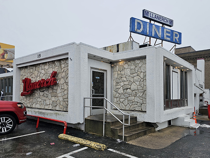 The neon glow of Llanerch Diner's iconic sign beckons hungry travelers like a lighthouse for the famished. Classic mint-green exterior and stone facade scream "authentic American diner experience."