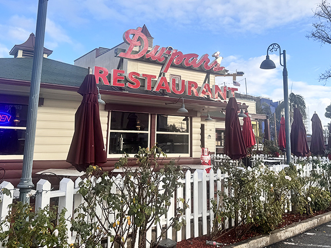 That iconic red neon sign isn't just announcing a restaurant&mdash;it's signaling your imminent reunion with pancake perfection at the edge of LA's historic Farmers Market.