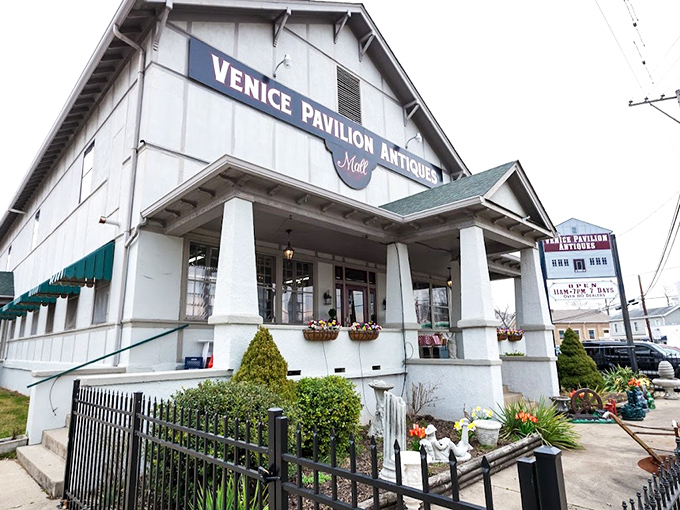 The white clapboard exterior of Venice Pavilion Antiques stands like a time capsule on the corner, promising treasures within that HGTV stars would battle over. 