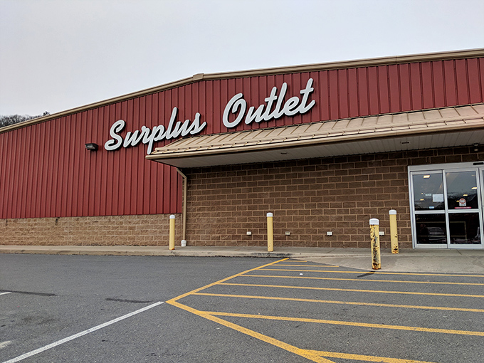 The crimson facade of Surplus Outlet stands like a temple to thriftiness, where shopping carts enter empty but leave triumphantly full.