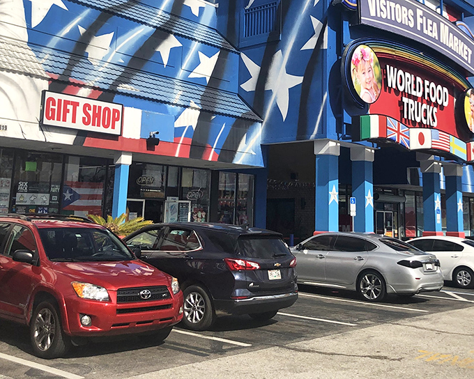 The star-spangled exterior of Visitors Flea Market promises patriotic bargain hunting with its bold blue facade and "WORLD FOOD TRUCKS" sign beckoning hungry shoppers.