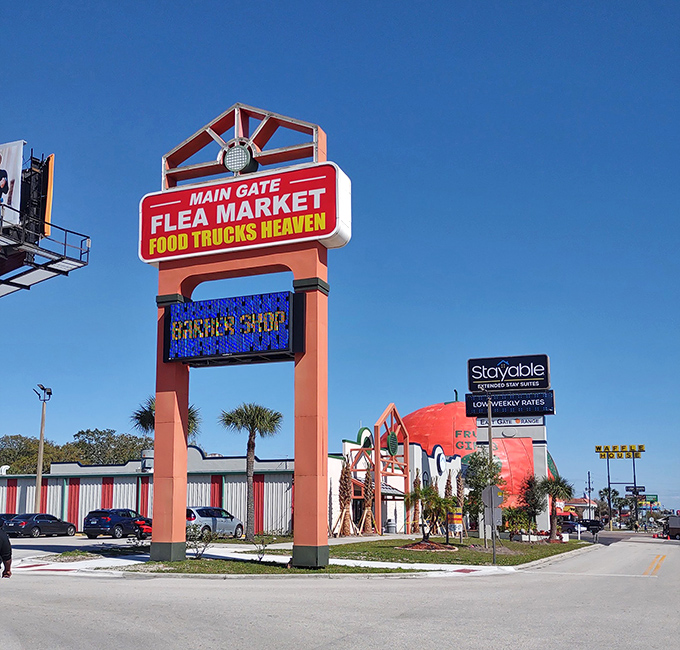 The iconic coral-colored entrance sign promises two of life's greatest pleasures: bargain hunting and street food. Florida's blue skies provide the perfect backdrop.