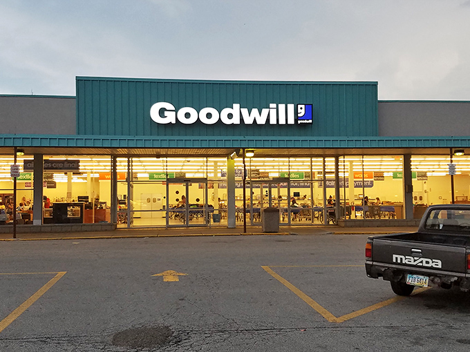 The unassuming facade of treasure-hunting paradise. At dusk, the Goodwill Outlet sign beckons bargain seekers like a retail lighthouse guiding ships to shore.