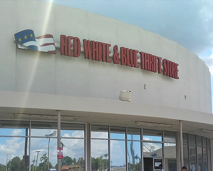 The iconic white facade of Red White & Blue Thrift Store stands proudly against the Florida sky, a patriotic beacon for bargain hunters everywhere.