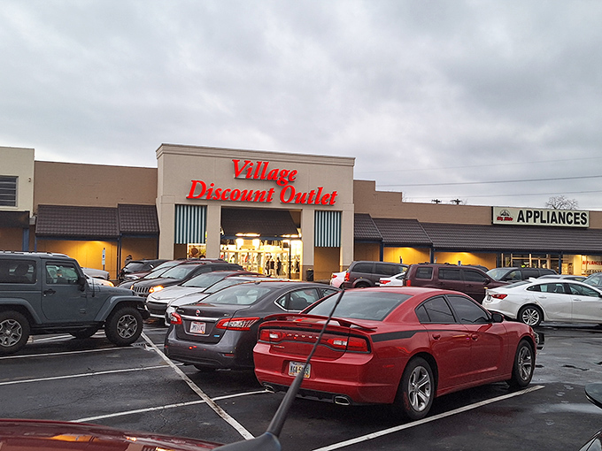 The iconic red lettering of Village Discount Outlet beckons bargain hunters like a retail lighthouse guiding ships to treasure-filled shores.