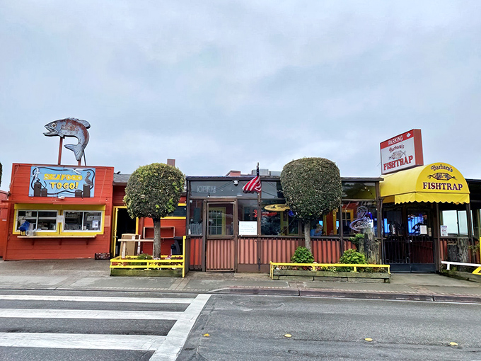 Barbara's Fishtrap stands proudly against the Half Moon Bay sky, its cheerful red exterior and giant crab sculpture announcing: seafood paradise ahead!