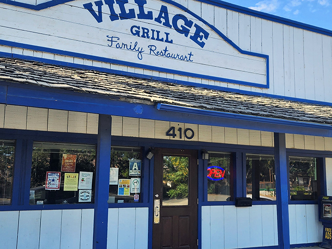 The blue-trimmed facade of Village Grill stands like a beacon of breakfast hope on Tehachapi Boulevard, promising comfort food salvation to hungry travelers.
