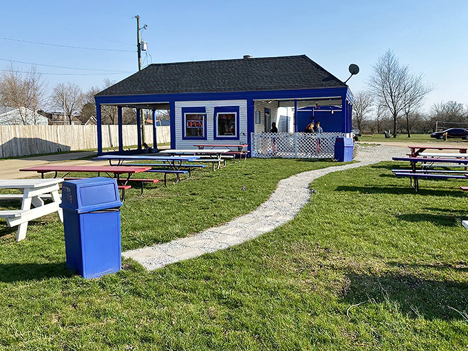The blue-roofed burger sanctuary beckons from the roadside, promising simple pleasures that no fancy restaurant could ever replicate.