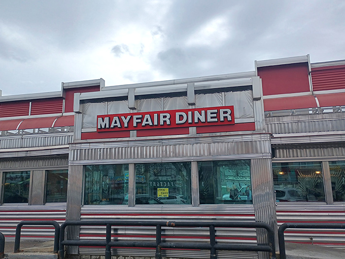 The gleaming stainless steel exterior of Mayfair Diner stands as a shiny time capsule on Frankford Avenue, beckoning hungry Philadelphians with its iconic red signage.