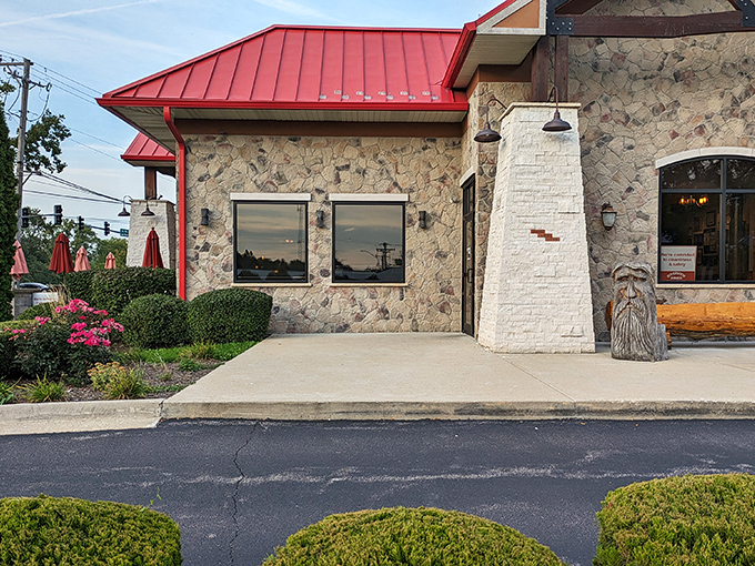 Stone and timber meet red metal roofing in this rustic-modern haven. The wooden bench outside practically whispers, "Stay awhile, friend."