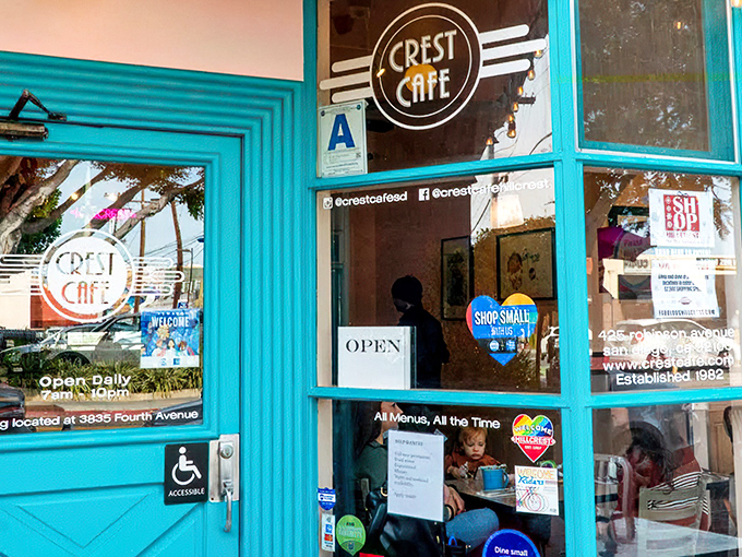 The turquoise-framed entrance to Crest Cafe stands out like a tropical oasis in Hillcrest, promising culinary adventures behind its welcoming doors.