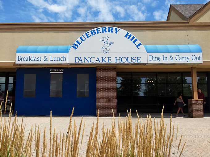 The blue awning of Blueberry Hill Pancake House stands out like a beacon for breakfast enthusiasts. This unassuming exterior houses morning magic within.