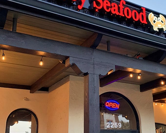 The glowing red sign of Juicy Seafood beckons like a lighthouse for hungry sailors. This unassuming exterior houses seafood treasures worth discovering.