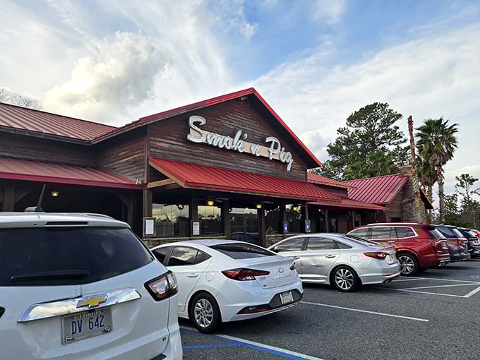 The sunset glow behind Smokin' Pig's rustic wooden exterior and signature red roof feels like nature's way of highlighting where dinner should happen tonight.