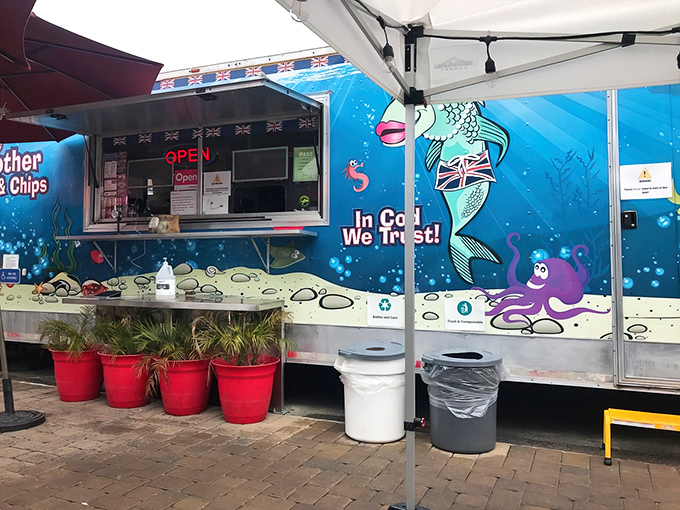 The bright blue food truck stands out like a maritime beacon at Fisherman's Wharf, promising British comfort food with its cheeky "In Cod We Trust" slogan.