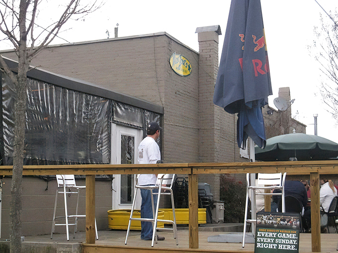 MoJoe's exterior beckons with its inviting green awnings and wooden patio. The perfect spot for burger enthusiasts to begin their culinary adventure.