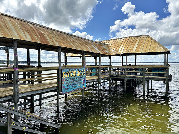 The iconic Gator Joe's entrance beckons with its wooden boardwalk and palm trees—Florida's version of a yellow brick road to seafood paradise.