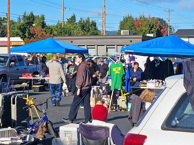 Treasure hunters navigate a sea of blue canopies, where one person's castoffs become another's prized possessions. Portland's weekend ritual of discovery unfolds.