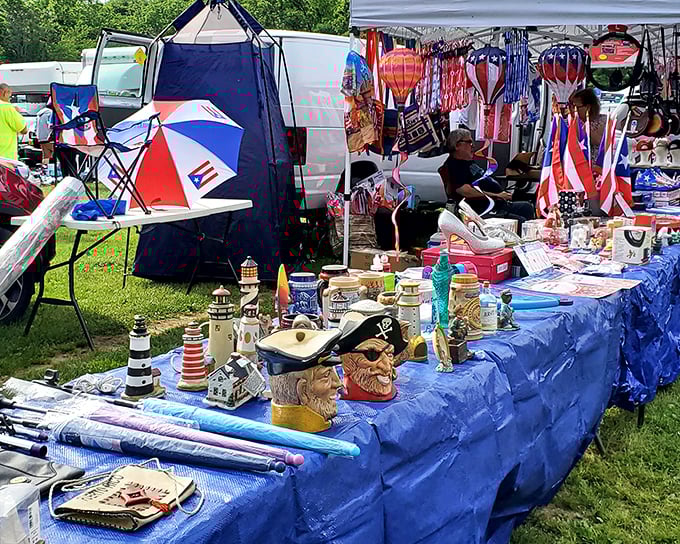 Treasure hunting paradise! Colorful umbrellas, nautical collectibles, and character mugs await discovery at this outdoor vendor's blue-draped wonderland.