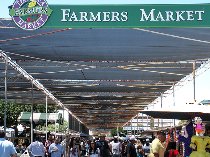 The covered walkways of the Farmers Market stretch toward the horizon like an endless bazaar, sheltering treasure hunters from the California sun.