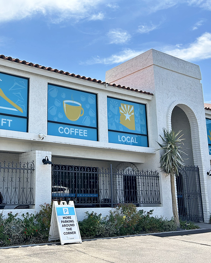 The pristine white exterior of Thrift to Thrive welcomes bargain hunters with its Mediterranean-inspired architecture and cheerful blue window displays.