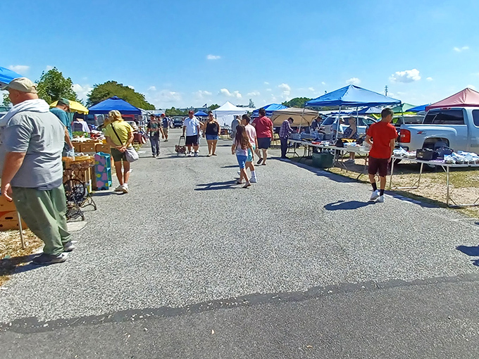 Treasure hunters navigate the outdoor market under blue canopies, where one person's castoffs become another's prized discoveries.