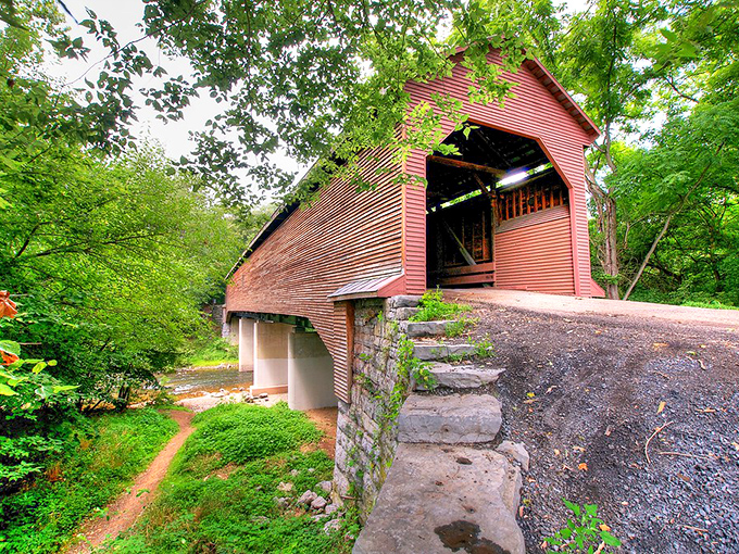 The crimson-colored Meem's Bottom Covered Bridge stands like a portal to the past, its weathered exterior perfectly framed by Virginia's lush greenery. 