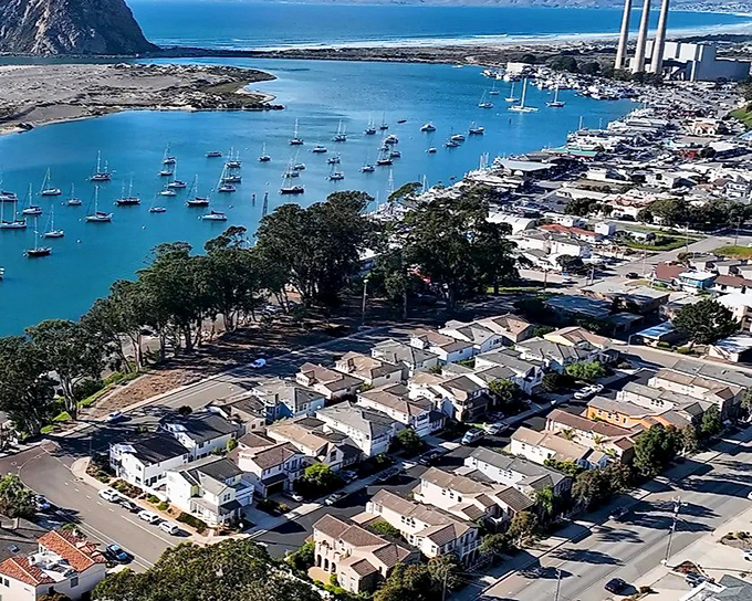 Morro Bay's iconic rock stands sentinel over a harbor dotted with sailboats, like nature's own lighthouse guiding travelers to this coastal haven.