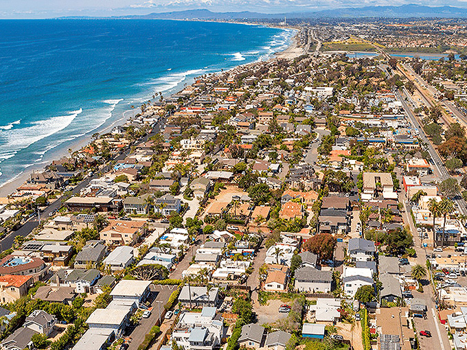 Beachfront paradise meets suburban dream in this aerial view of Encinitas, where the Pacific kisses the coastline like an old friend returning home.