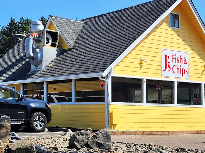 The yellow beacon of seafood salvation! J's Fish & Chips stands out with its cheerful exterior and that quirky robot guardian keeping watch from above.
