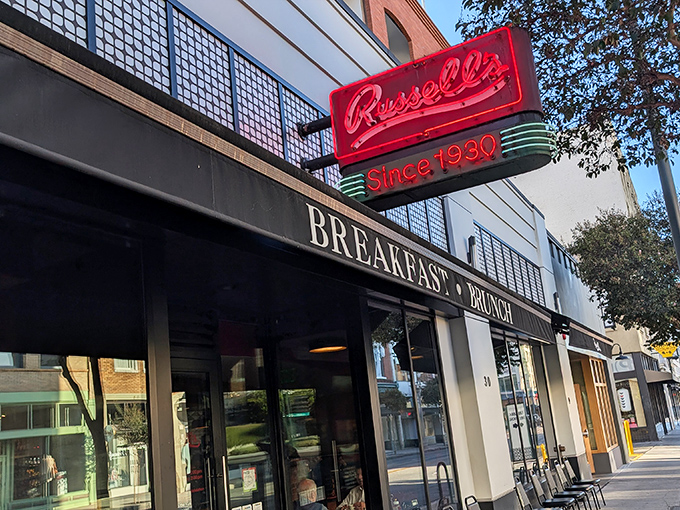 The iconic red neon sign beckons hungry Pasadenans like a breakfast lighthouse, promising comfort and nostalgia since 1930.