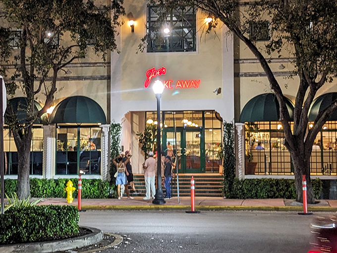 The iconic green awnings of Joe's Take-Away beckon like an old friend at twilight, promising seafood treasures within this Miami Beach landmark. 