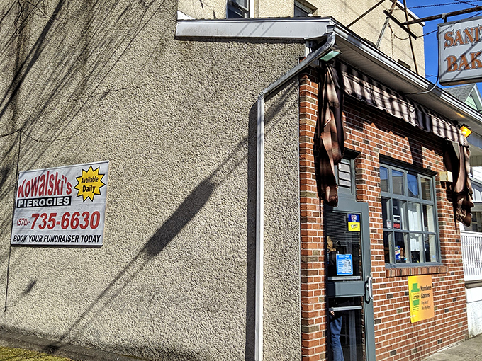The iconic Sanitary Bakery sign hangs proudly above the brick storefront, promising cleanliness and deliciousness in equal measure.
