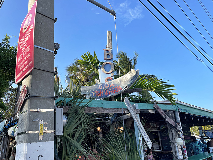 The iconic wooden fish sign of B.O.'s Fish Wagon stands sentinel against the Key West sky, promising seafood salvation to hungry travelers.