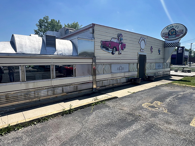The classic stainless steel exterior of Nancy's Main Street Diner gleams in the sunlight, a time capsule of Americana waiting to transport hungry visitors back to simpler times.