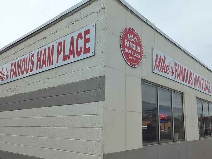 The unassuming white exterior of Mike's Famous Ham Place stands like a culinary lighthouse on Michigan Avenue, beckoning hungry travelers with its iconic red sign since 1974.