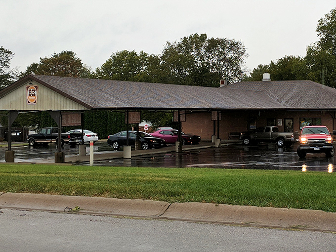 The classic drive-in canopy at B & K Root Beer Stand beckons like a time portal to simpler days when carhops and conversation were the original social media.